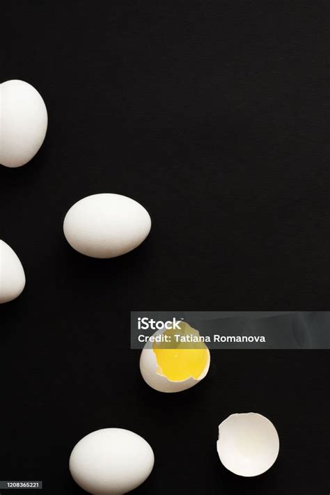 흰 달걀은 검은 배경에 흩어져 있습니다 달걀 한 개가 부러지고 노른자가 보입니다 미니멀 한 디자인과 색상 트렌드 2020 맨 위 보기 0명에 대한 스톡 사진 및 기타 이미지