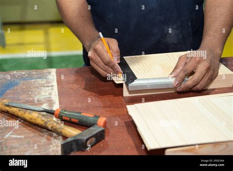 Hands Of A Carpenter Man Taking Measurements And Marking Them Stock