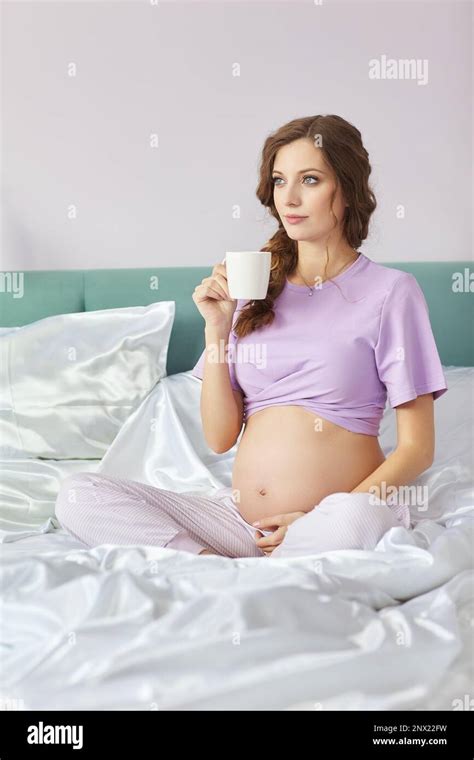 A Pregnant Woman Lies In Bed Of Her Domestic Bedroom Female Dressed In