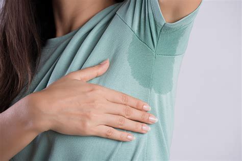 다한증 땀이 클로즈업 아시아 여자 회색 배경에 대 한 그녀의 옷에 땀 얼룩을 가진 젊은 아시아 여자 헬스케어 개념 땀에 대한