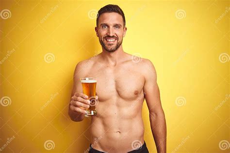 Young Handsome Shirtless Man Drinking A Pint Of Beer Over Isolated