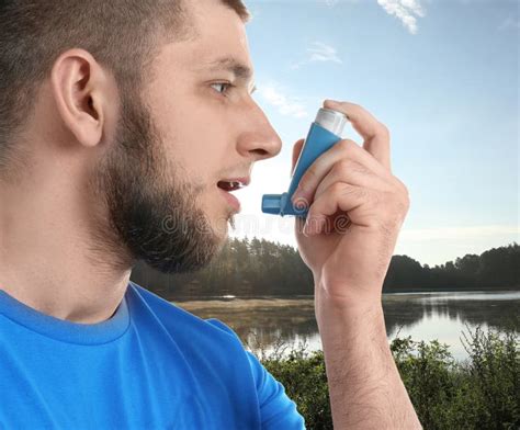 Man Using Asthma Inhaler Near Lake Emergency First Aid During Outdoor
