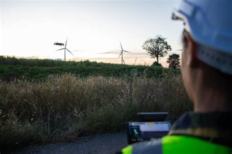 Asian Female Engineer Using Drone For Inspection Wind Turbine Farm In
