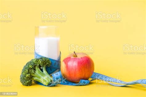 노란 배경에 우유 브로콜리 파란색 측정 테이프와 빨간 사과의 유리 다이어트와 체중 감소 개념 복사 공간 0명에 대한 스톡 사진