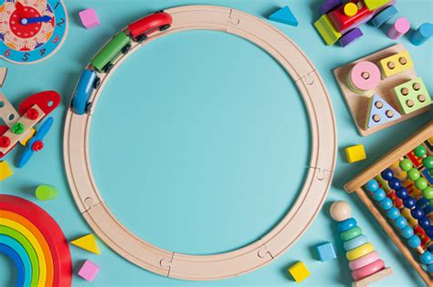 아기 아이 장난감 프레임 배경입니다 기차와 밝은 파란색 배경에 다채로운 지속 가능한 교육 장난감이 있는 나무 철도 몬테소리