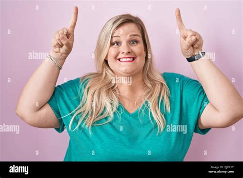 Caucasian Plus Size Woman Standing Over Pink Background Smiling Amazed