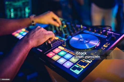전문 Dj는 해변 나이트 클럽의 무대에서 턴테이블 콘솔에서 라이브 세트와 믹싱 음악을 연주합니다 클럽 파티에서 사운드 믹서 스테이션에 디스크 조키 손 음악과 파티를 재생하기