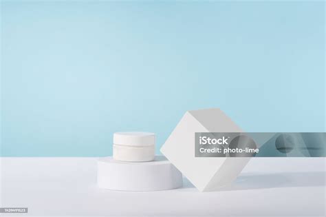 화장품 고급 크림 항아리 병 모형은 받침대 연단에 파란색 배경에 있습니다 브랜드가없는 로션 미용 제품 포장 제품 프레젠테이션 모형 로션 무스 스킨케어 루틴을 위한 클렌저 0