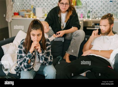 Candid Family Moment Engaged And Concerned Expressions Captured In A Cozy Setting Stock Photo