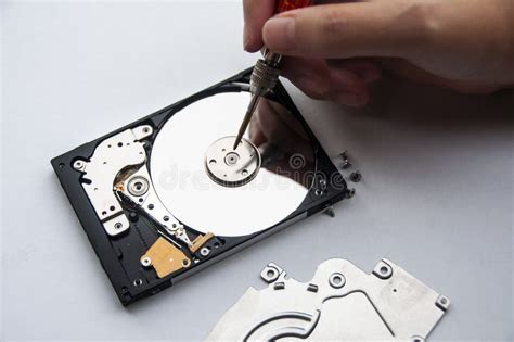 The Abstract Image Of Inside Of Hard Disk Drive With Technician Fixing Using Driver On White