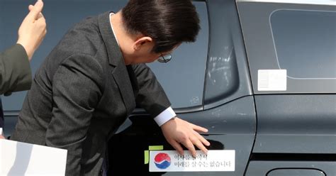 차량에 태극기 스티커 붙이는 이재명 대