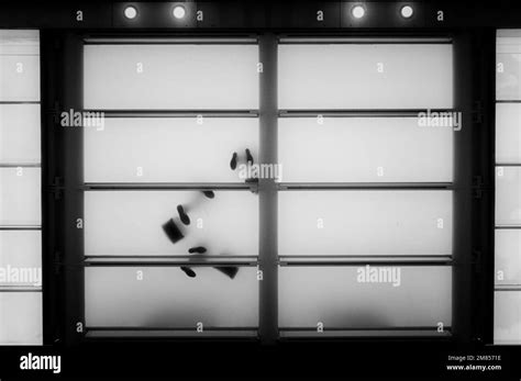 A Low Angle View Of A White Glass Floor In An Elevator With Silhouettes