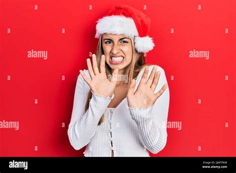 Beautiful Hispanic Woman Wearing Christmas Hat Afraid And Terrified