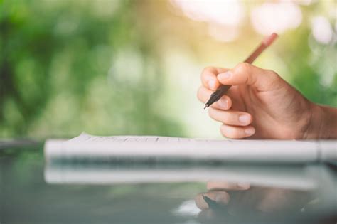 자연 녹색 보케 태양 빛 추상적 인 배경과 커피 숍에서 종이에 펜 쓰기를 사용하여 여성 손 교육 학습 및 비즈니스 라이프 스타일 개념의 공간을 복사합니다 빈티지 톤 필터