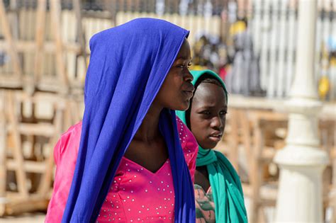 Touba Mouride 형제 애의 집의 큰 모스크에에서 미확인된 세네갈 여자 색 전통 옷을 입고 산책 건축에 대한 스톡 사진