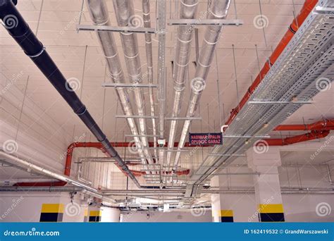 Water Pipes And Cable Trays Run Under Ceiling Of A Building Stock Photo