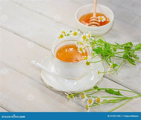 Шар заполнил с медом и ложкой цветка с чашкой чаю Стоковое Изображение
