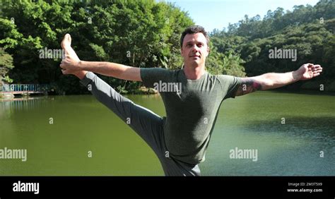 Person Practicing Yoga Outside Standing In One Leg Stretching Body