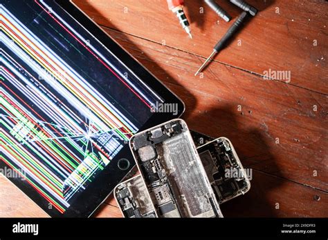 A Broken Tablet With A Colorful Distorted Screen And Two Disassembled