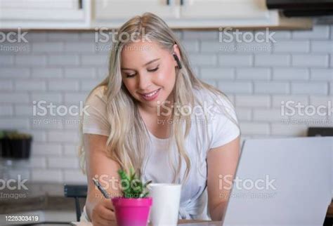 원격으로 작업하는 동안 화상 회의 중에 메모를 하는 여성 가정 주방에 대한 스톡 사진 및 기타 이미지 가정 주방 가정의 방