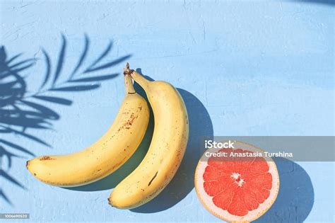 신선한 바나나 자 몽 고립 된 밝은 파란색 배경 상위 뷰 평면 배치 공간 여름 개념 최소한 그림 열 대 잎 그림자 구성 복사 0