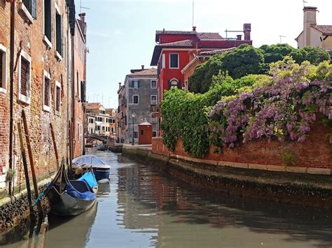 Premium Photo Canal In Venice In Italy With Boat And Flowers