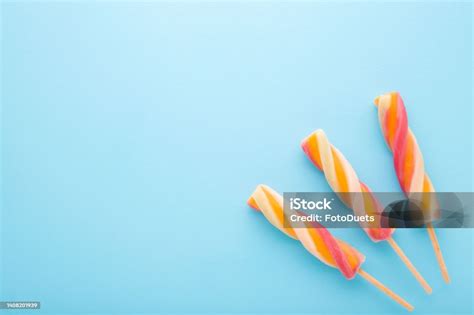 막대기에 세 가지 다채로운 과일 얼음 팝시클 밝은 파란색 테이블 배경 파스텔 색상 근접 촬영 여름에는 차가운 달콤한 스낵 텍스트의 빈 위치입니다 하향식 보기 Popsicle