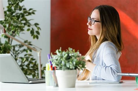 Schöne Junge Frau Arbeitet Mit Laptop In Ihrem Büro Kostenlose Foto