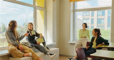 A Group Of Girls Sitting On A Window Sill Photo Classroom Fashion
