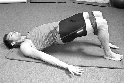 Supine Bridge With Resisted Hip Abduction The Patient Places The Feet