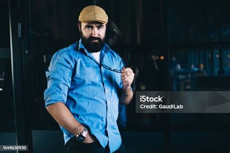 어두운 배경에 실내에 서서 직업과 계획에 대해 생각하는 캐주얼 웨어를 입은 남자의 절반 길이 초상화 잠겨 있는 심각한 자신감 있는 성숙한 40대 수염 난 남성이 카메라를