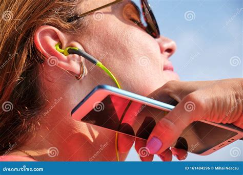 Woman With Sunglasses And Earphones Listening To Music And Looking