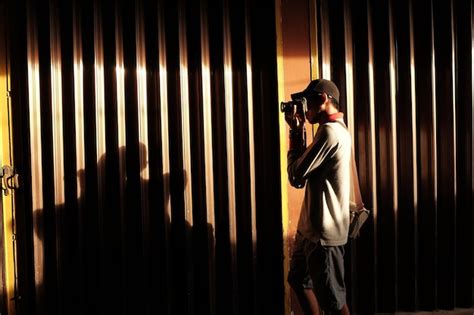 Premium Photo Side View Of Man Photographing Through Camera While Standing By Shutter