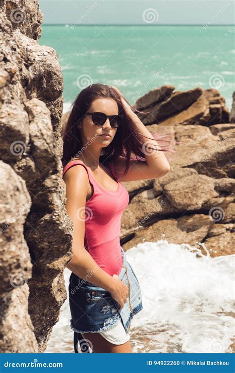 La Ragazza Sexy In Maglietta Rosa Vicino Alla Borsa Oscilla Fotografia