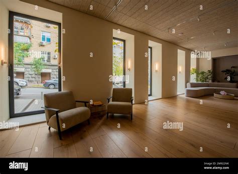 Modern Armchairs Near Round Coffee Table In Spacious Lobby Of Hotel