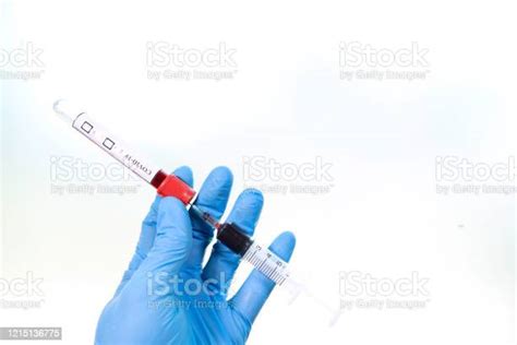 주사기에서 혈액 샘플의 수집 코로나 바이러스를 감지하려면 Covid19 손에 흰색 배경에 분리 파란색 보호 장갑을 착용