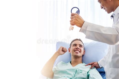 Happy Male Patient Lying On Hospital Bed And Pose Thumbs Up Stock Photo