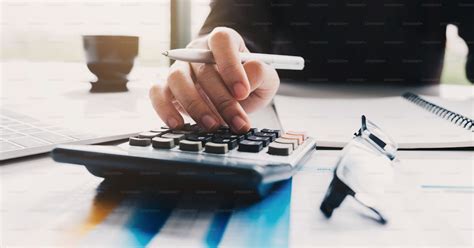 사무실 및 비즈니스 작업 배경 세금 회계 통계 및 분석 연구 개념에서 나무 책상에 수학 금융을 수행하기 위해 계산기와