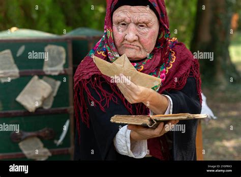 Elderly Fortune Teller Is Holding A Paper Boat And An Open Book