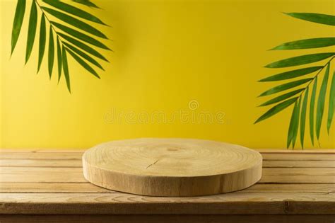 Empty Wooden Log With Palm Tree Leaves On Wooden Table Over Yellow