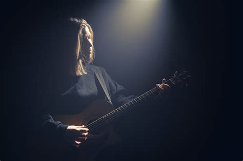 빛의 광선 아래 어둠 속에서 어쿠스틱 기타를 가진 젊은 여성 20 24세에 대한 스톡 사진 및 기타 이미지 20 24세 Classical Concert