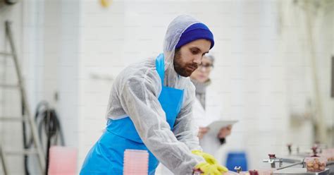 해산물 가공 공장에서 생산 라인으로 일하는 보호복을 입은 청년 사진 Unsplash의 러시아 이미지