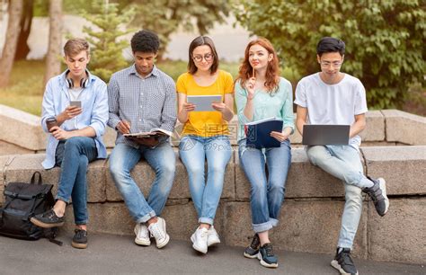 利用笔记本电脑和石板电脑在大学校园外门一起坐在一起学高清图片下载 正版图片503775105 摄图网