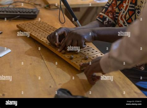 Blind African Person Learning To Use The Braille Number Tablet Under