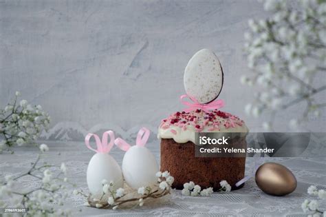달걀 모양의 진저브레드 토퍼 색깔 있는 달걀 토끼 귀를 곁들인 부활절 케이크가 있는 가벼운 부활절 테이블 행복한 부활절