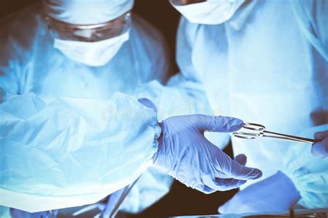 Surgeons Hands Holding Surgical Scissors And Passing Surgical Equipment