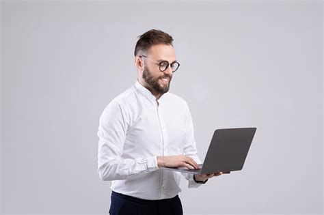 회색 스튜디오 배경 위에 노트북 컴퓨터를 사용하여 사무실 착용에 미소 젊은 사람 Brand Name Online