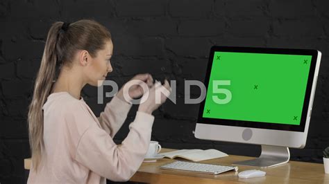 woman using computer with green screen