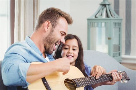 Homem Tocando Violão Com Sua Filha Em Casa Foto Premium