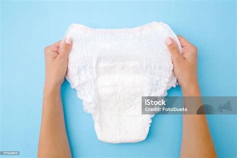 파스텔 블루 배경에 흰색 성인 기저귀를 들고 여자 손 근접 촬영 시점 샷 맨 위 보기 성인에 대한 스톡 사진 및 기타 이미지